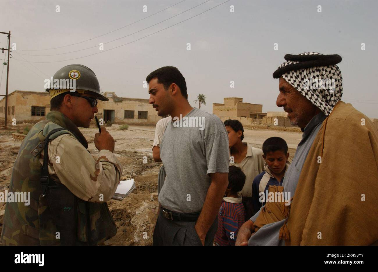 US Navy Utilitiesman 1st Class talks to a community elder through an ...