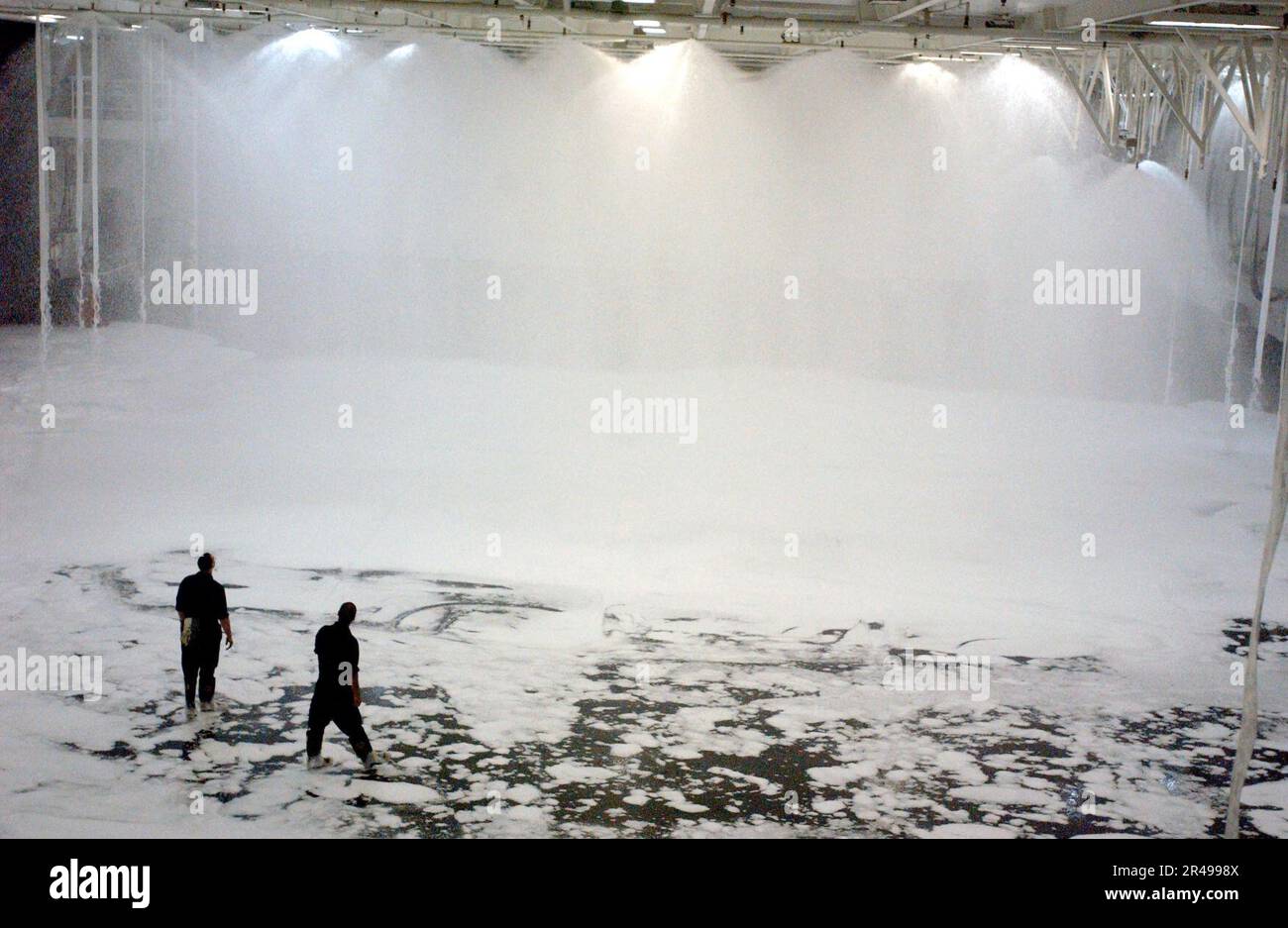 US Navy Damage Controlmen inspect the ship's hangar bay damage control ...