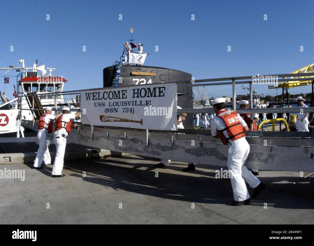 US Navy Line handlers make ready the gangway for the crew of the USS ...