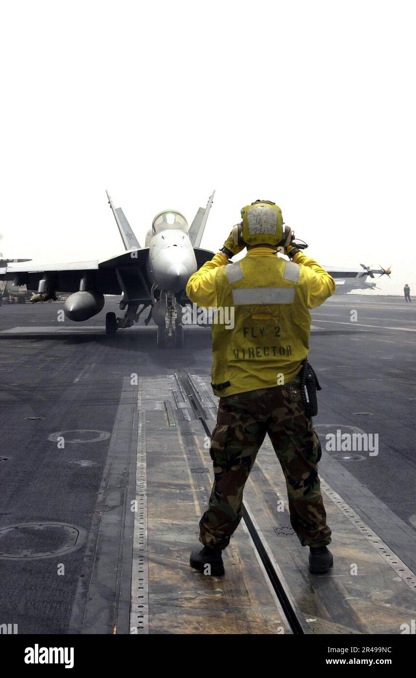 US Navy Aviation Boatswain's Mate 1st Class directs an F-A-18E Super ...