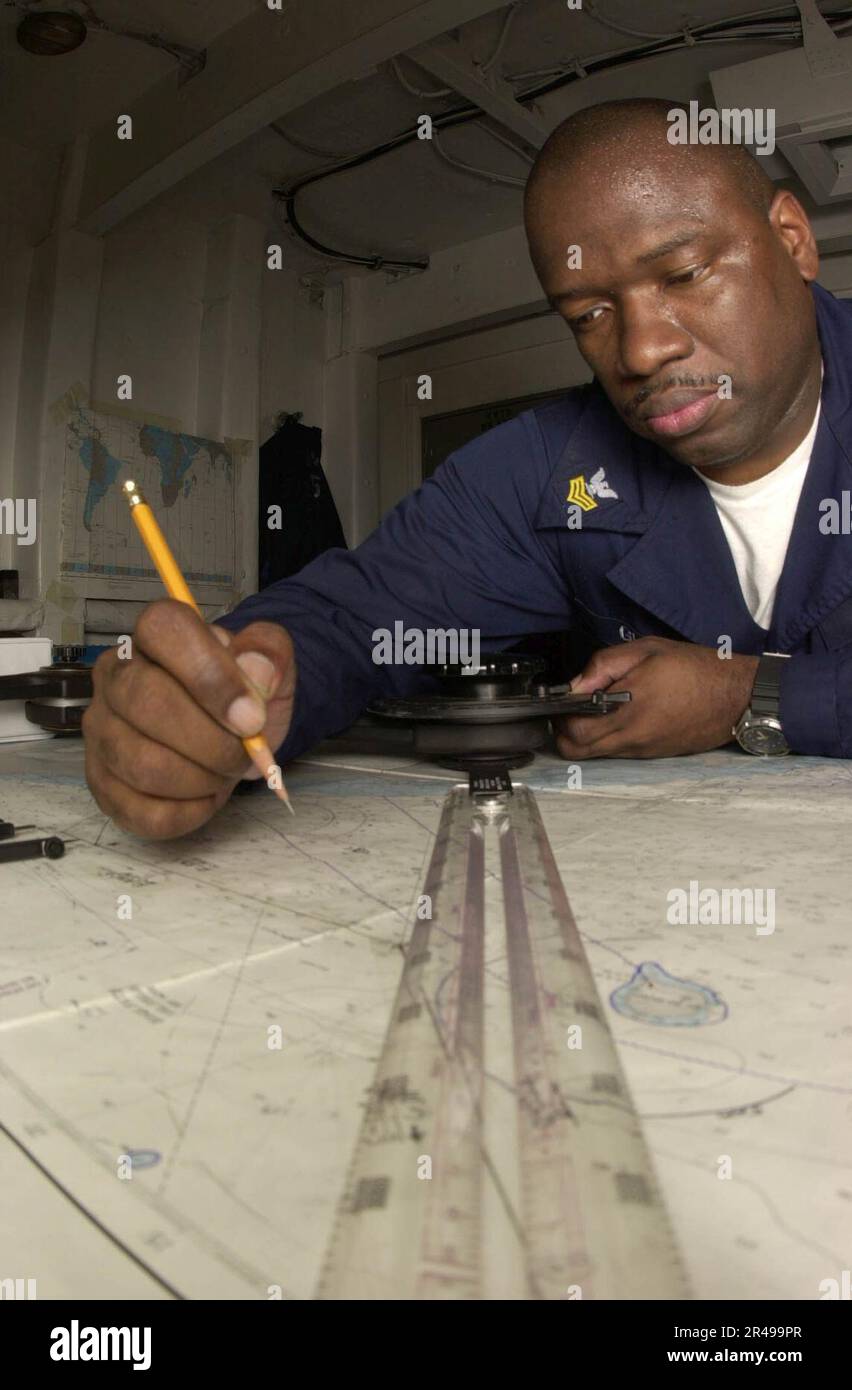 US Navy Quartermaster 1st Class checks the accuracy of a nautical map ...