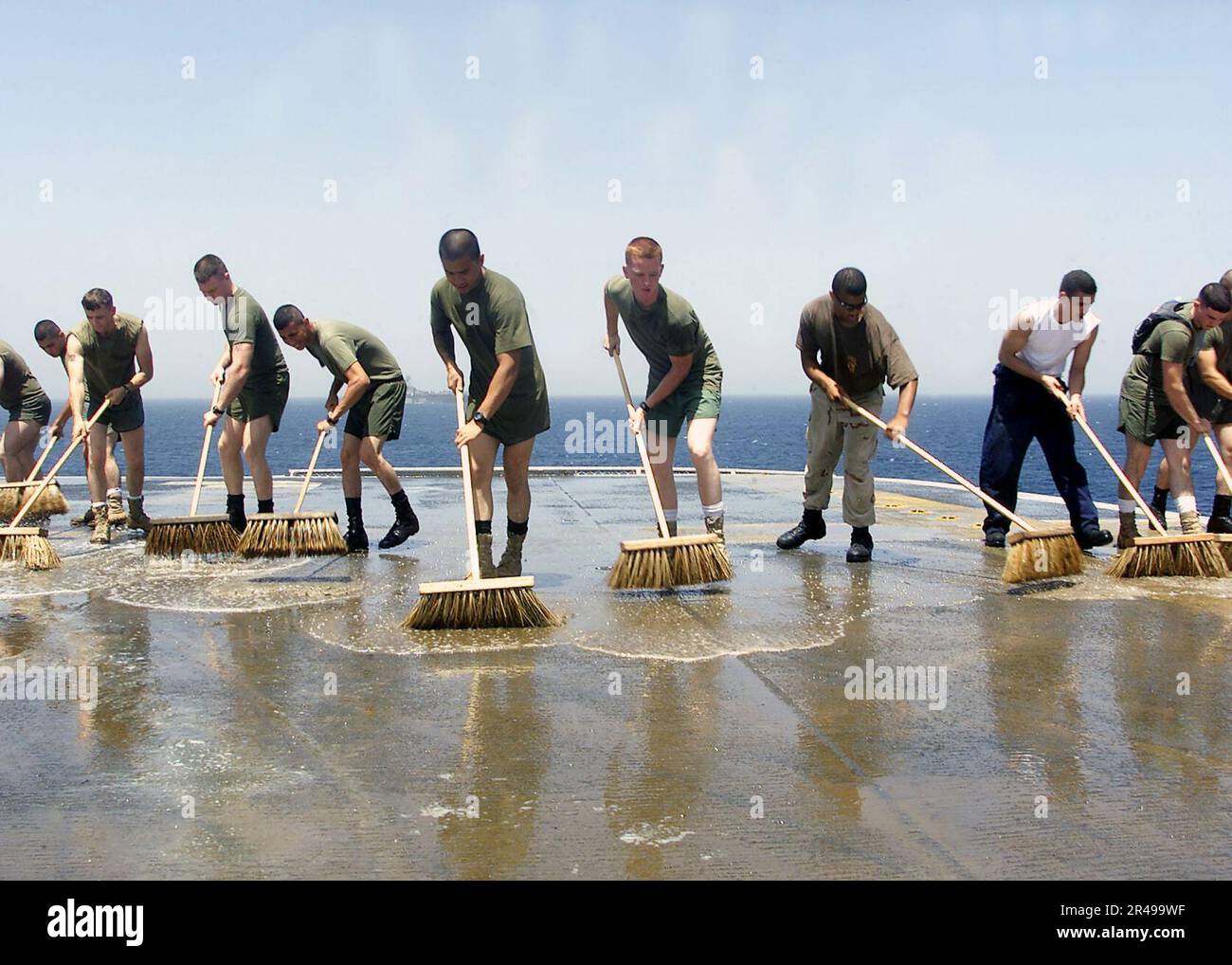 US Navy Sailors and embarked Marines flood the flight deck with salt ...