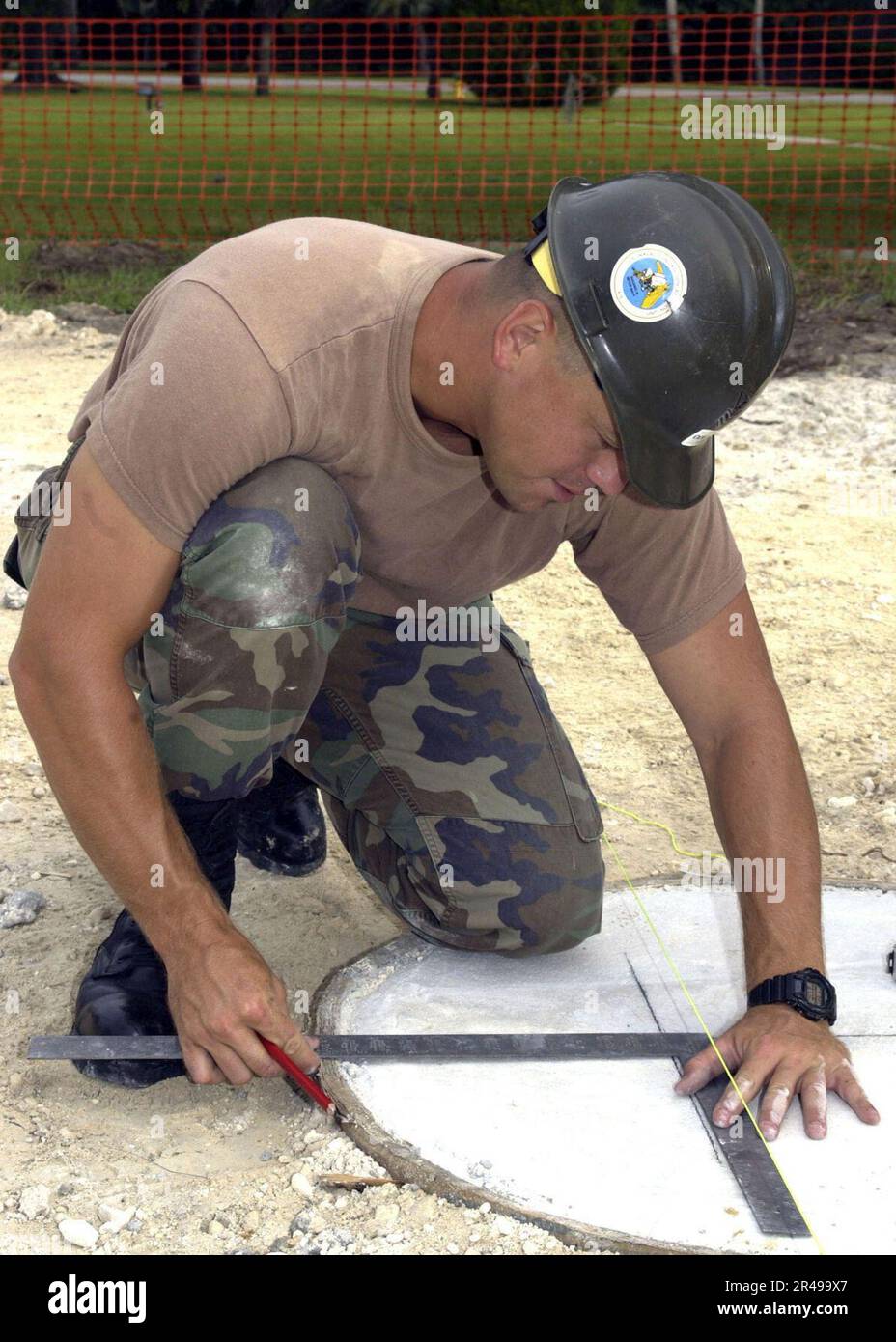 US Navy Builder 1st Class carefully measures to ensure the proper ...