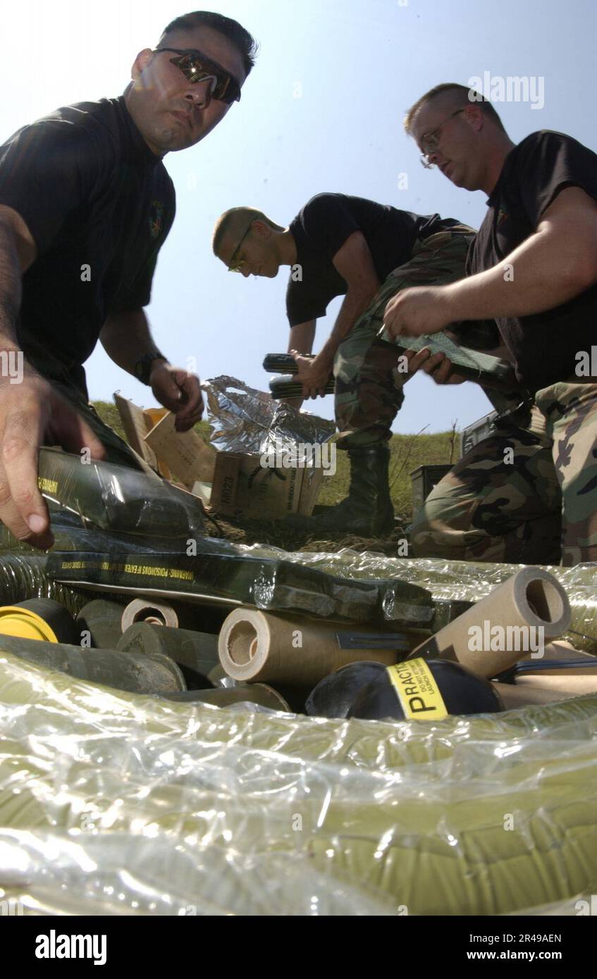 US Navy Explosive Ordnance Disposal Technicians prepare a clean-up ...