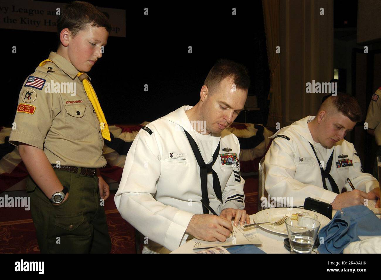 US Navy Operations Specialist 1st Class signs an autograph for a young ...