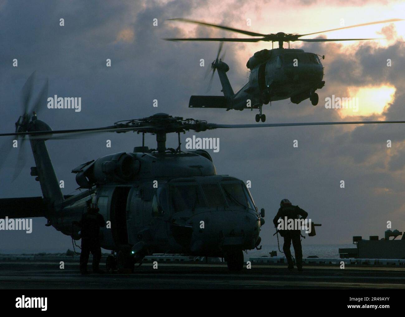 US Navy Airmen rush to chock and chain an SH-60F Sea Hawk helicopter ...
