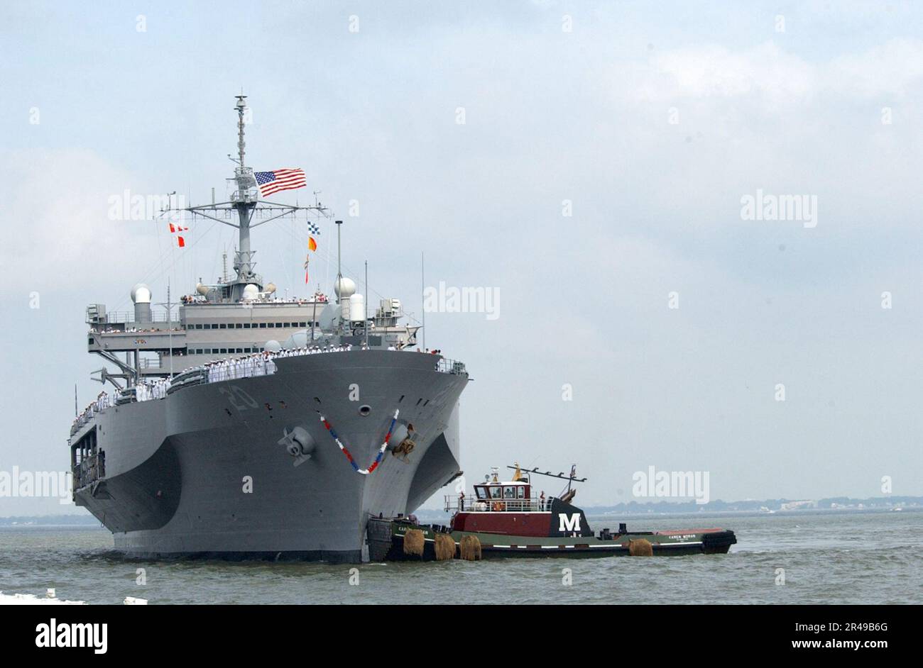 US Navy Tugboats assist the amphibious command and control ship USS ...