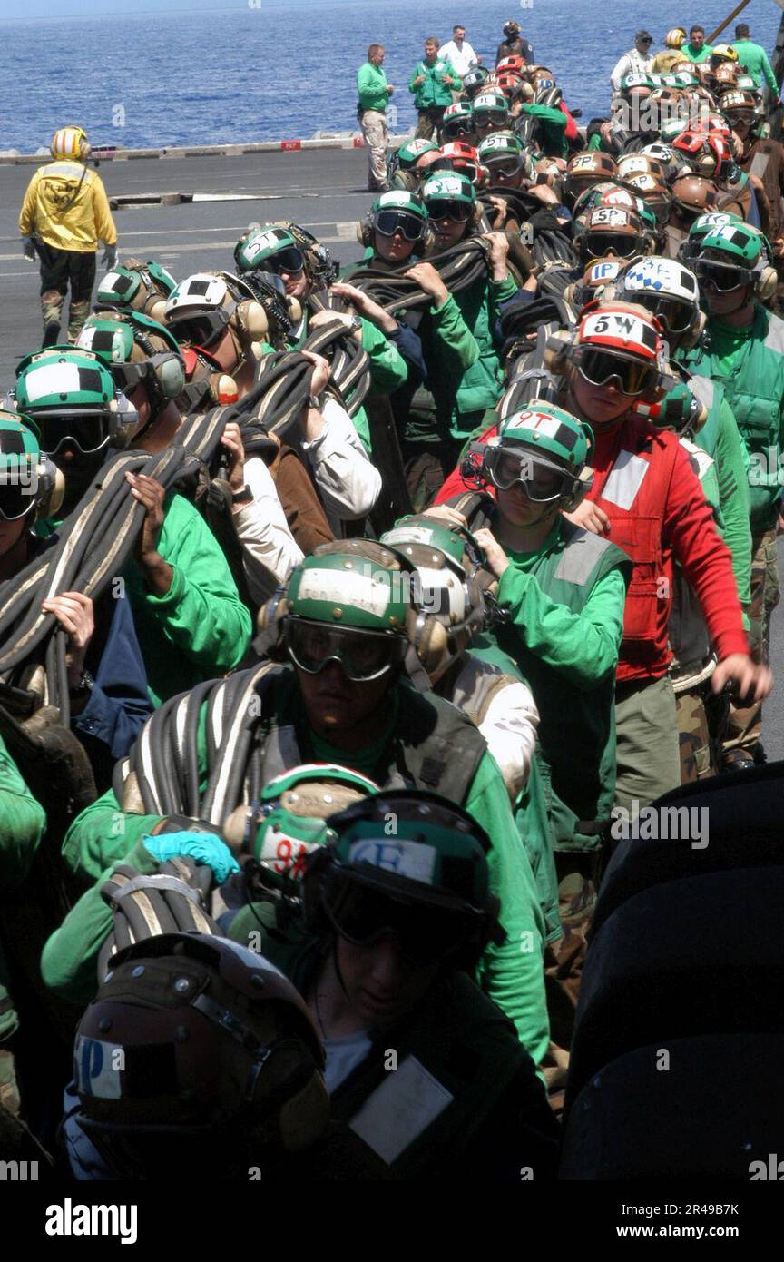 US Navy Flight deck personnel work together to re-stow the fixed wing ...