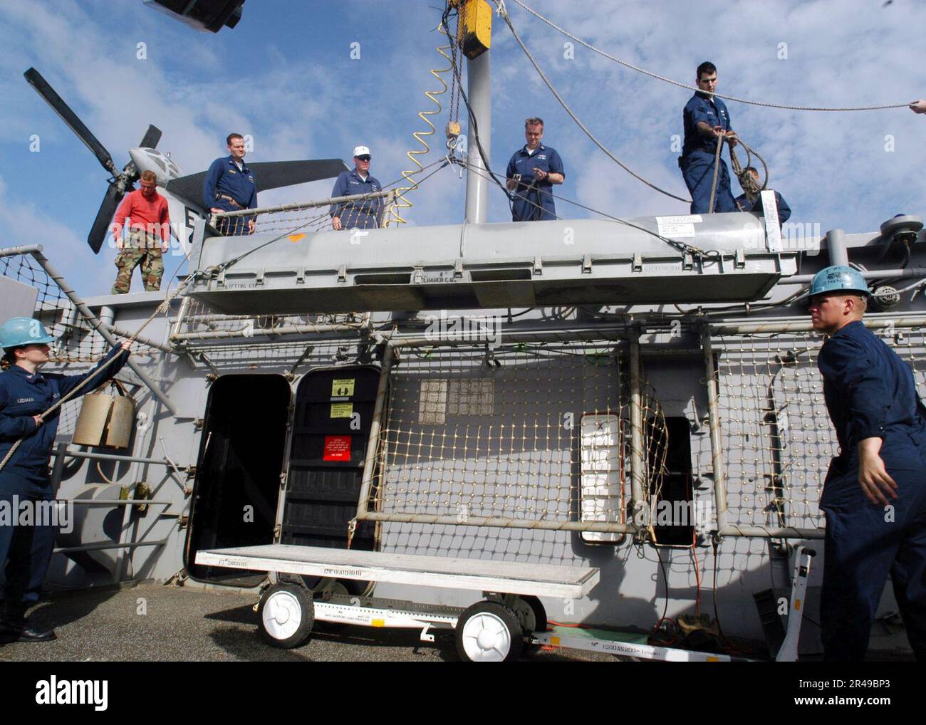US Navy Fire Control Technicians transport a missile from the launcher ...