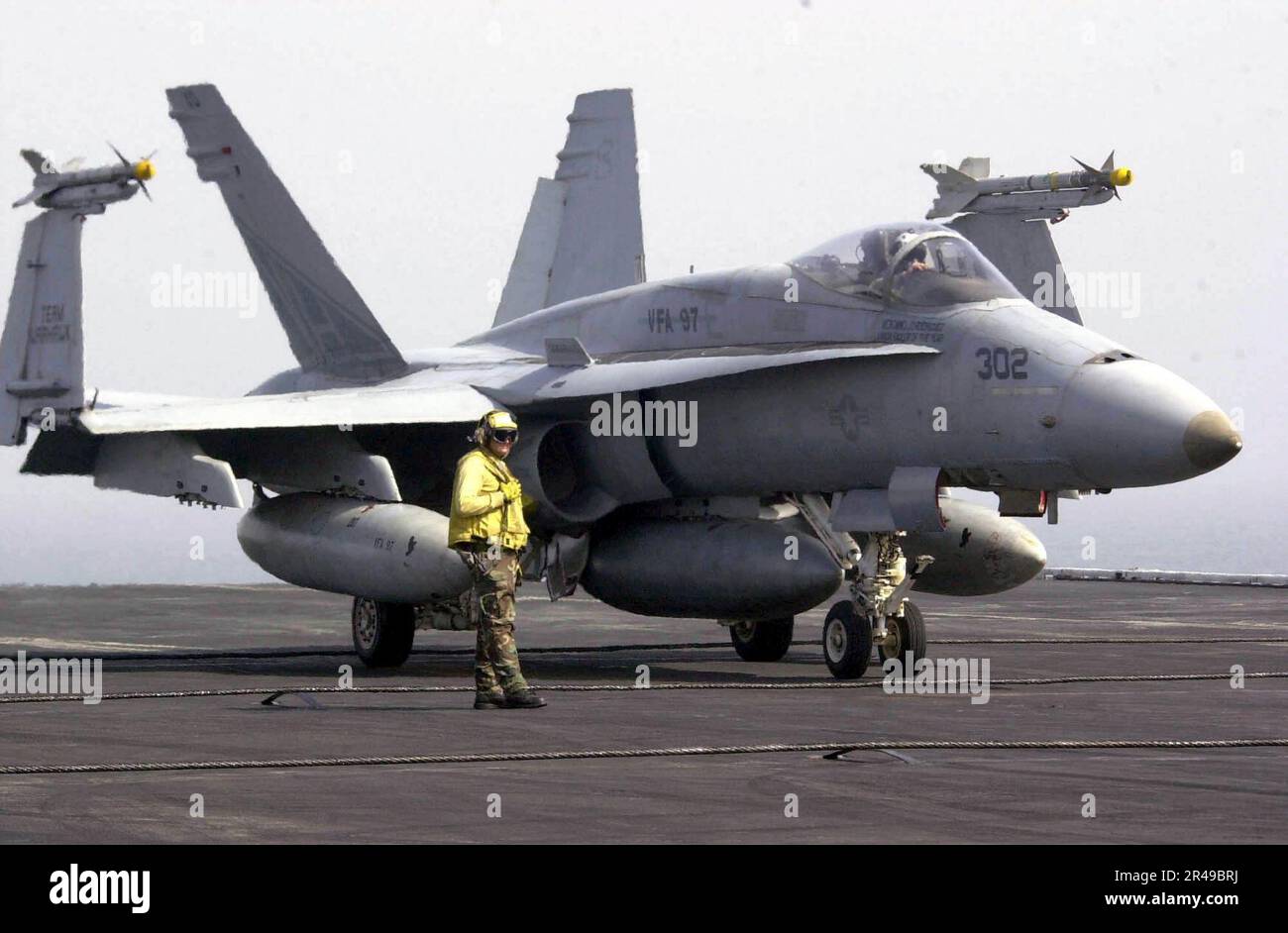 US Navy A plane director prepares to assist an F-A-18 Hornet to one of ...