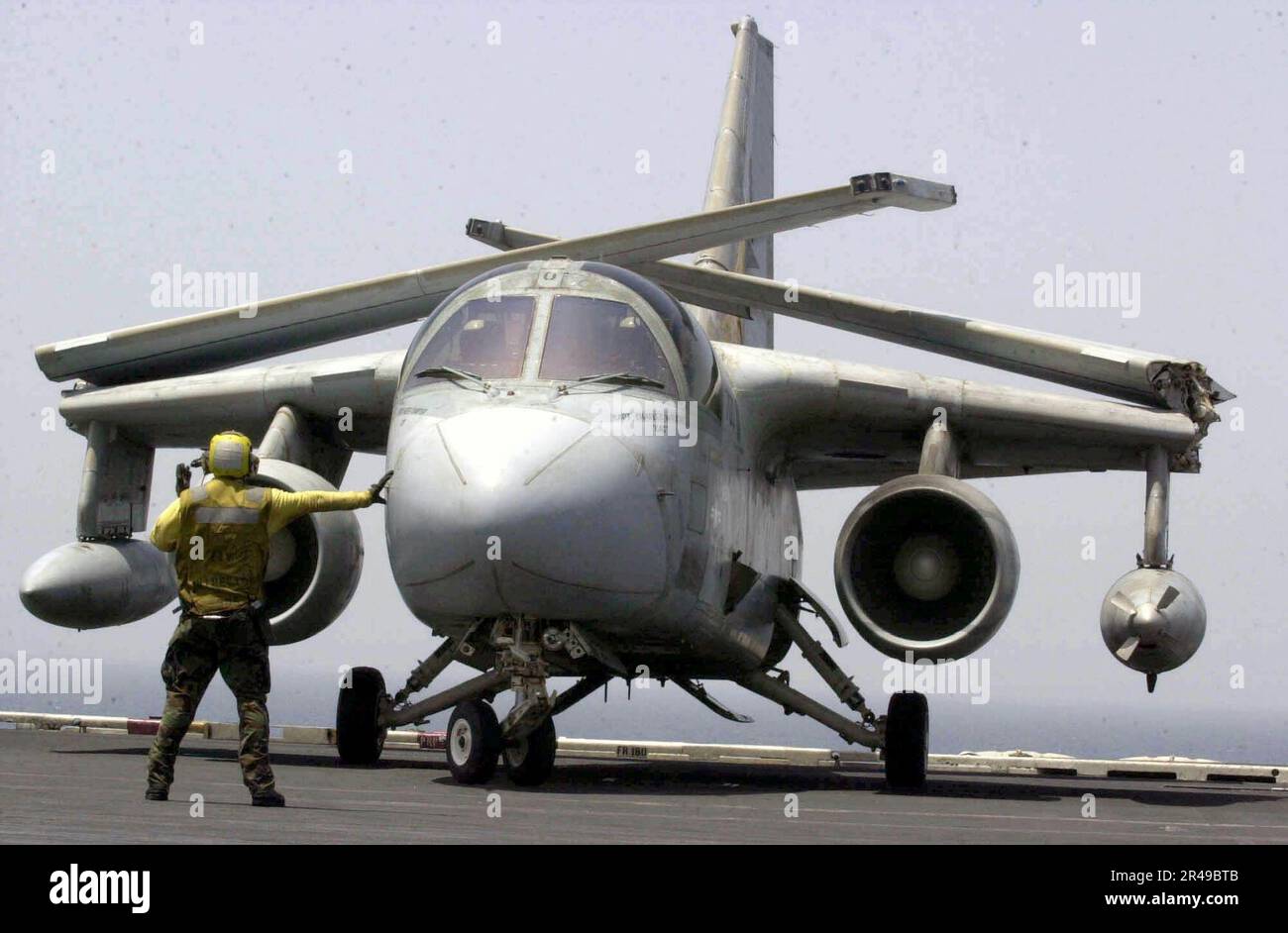 US Navy A flight deck handler directs an S-3B Viking onto one of the ...