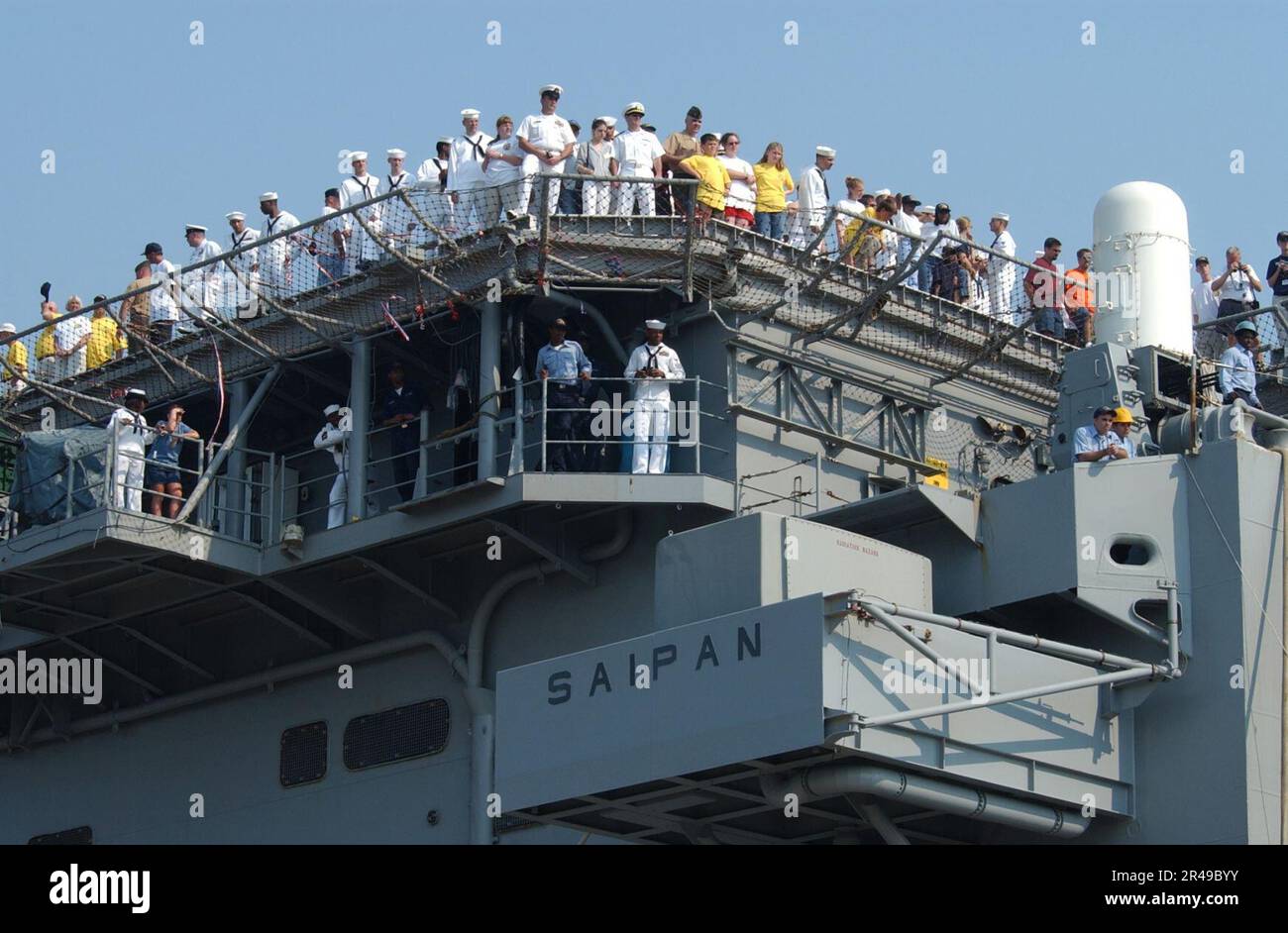US Navy Sailors and Tiger Cruise participants line up on the fantail to ...