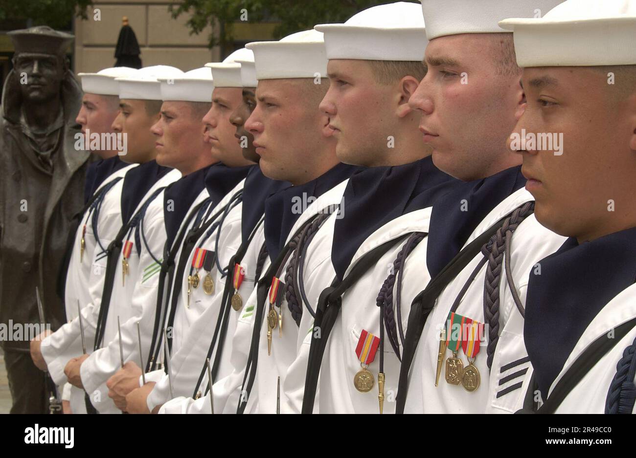 US Navy Members of the U.S. Navy Ceremonial Guard stand in formation next to the Lone Sailor ...