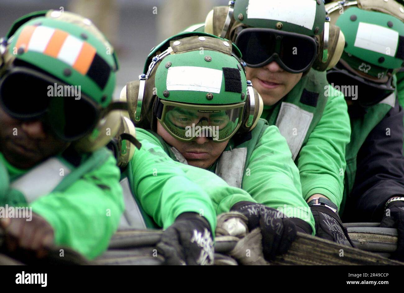 US Navy Flight deck crew members conduct an aircraft barricade rigging ...