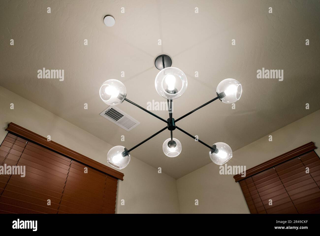 A stylish bedroom interior featuring a decorative light fixture ...