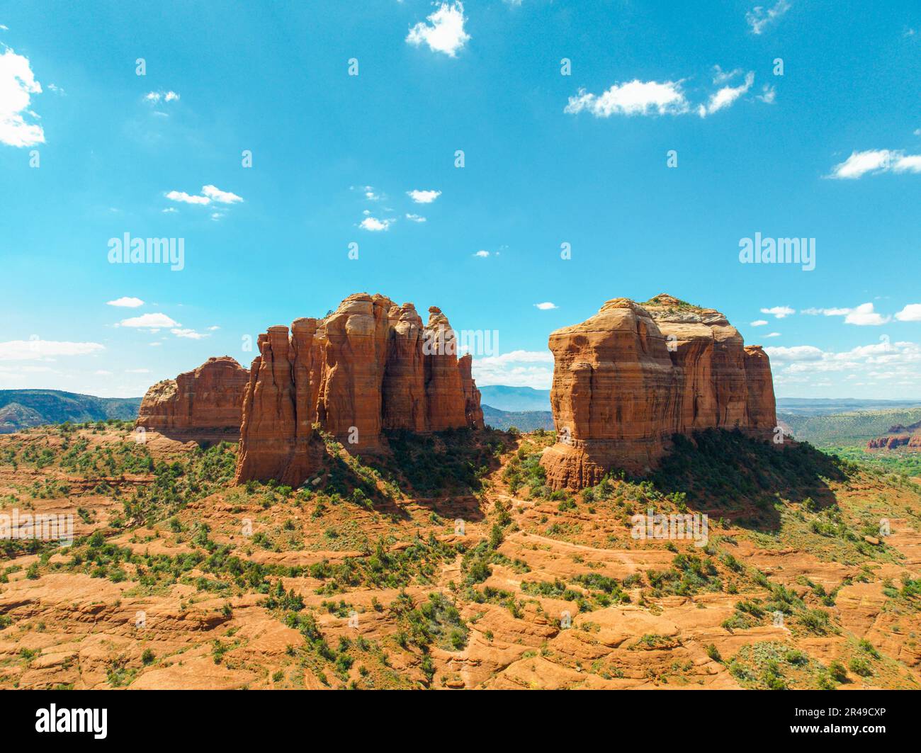 A scenic landscape featuring towering rock formations, lush green ...