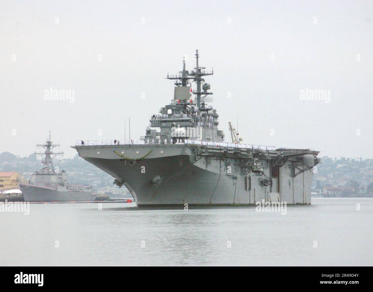 US Navy Sailors man the rail as the amphibious assault ship USS Boxer ...