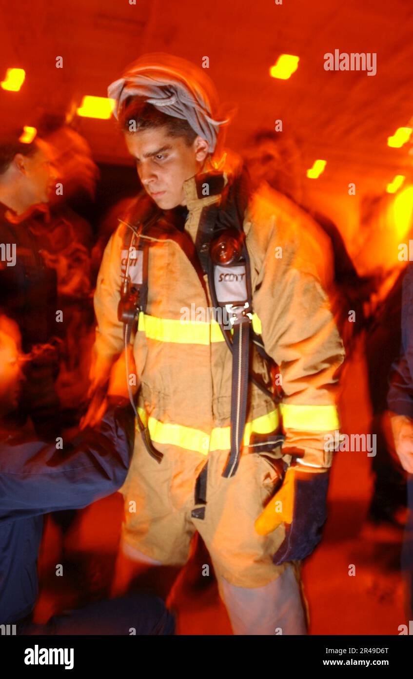 US Navy Midshipman Daren McCulley dons a firefighting ensemble during a ...