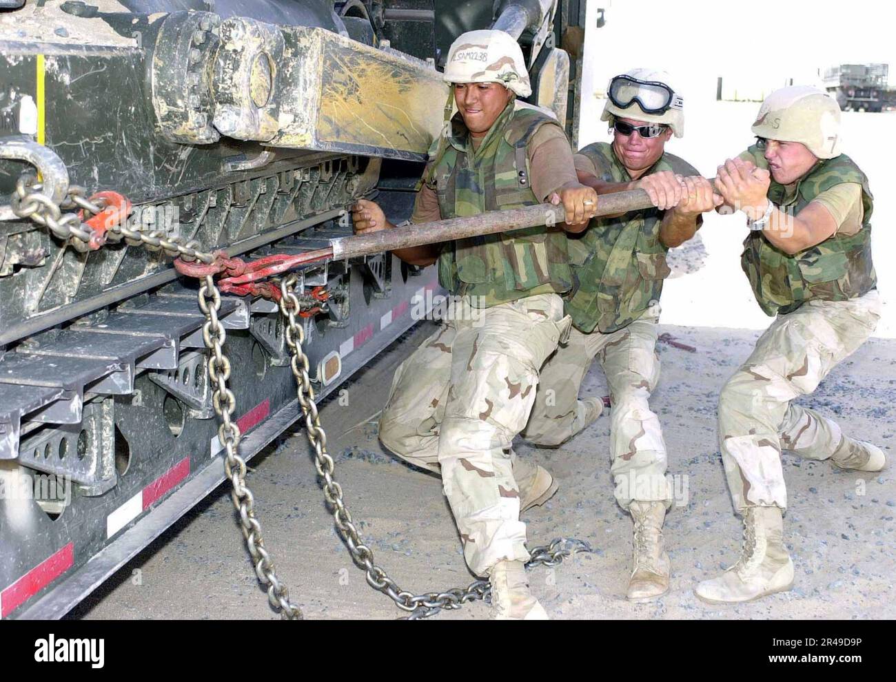 US Navy Seabees use a breaker bar to secure a bulldozer before ...