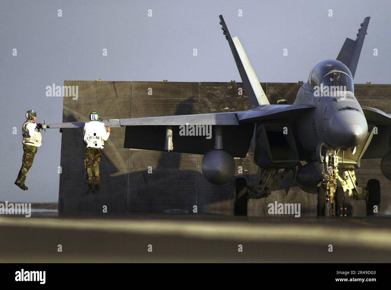 US Navy Final checkers leap in the air to inspect the aileron of an F-A ...