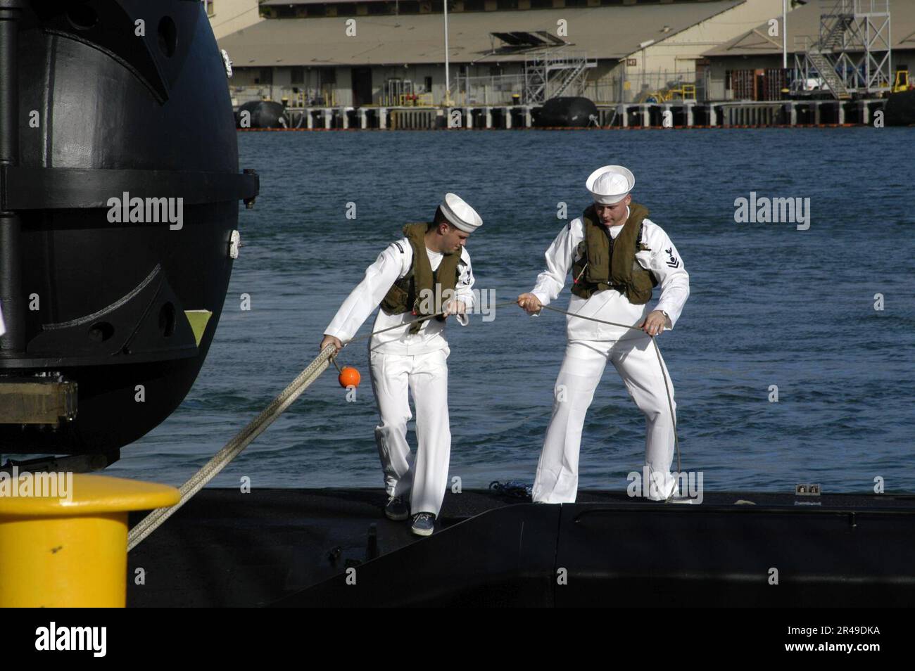 US Navy Line handlers aboard USS Los Angeles (SSN 688) bring mooring ...