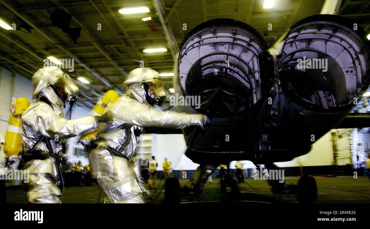 US Navy Firefighting sailors visually inspect the exhaust outlets of an ...
