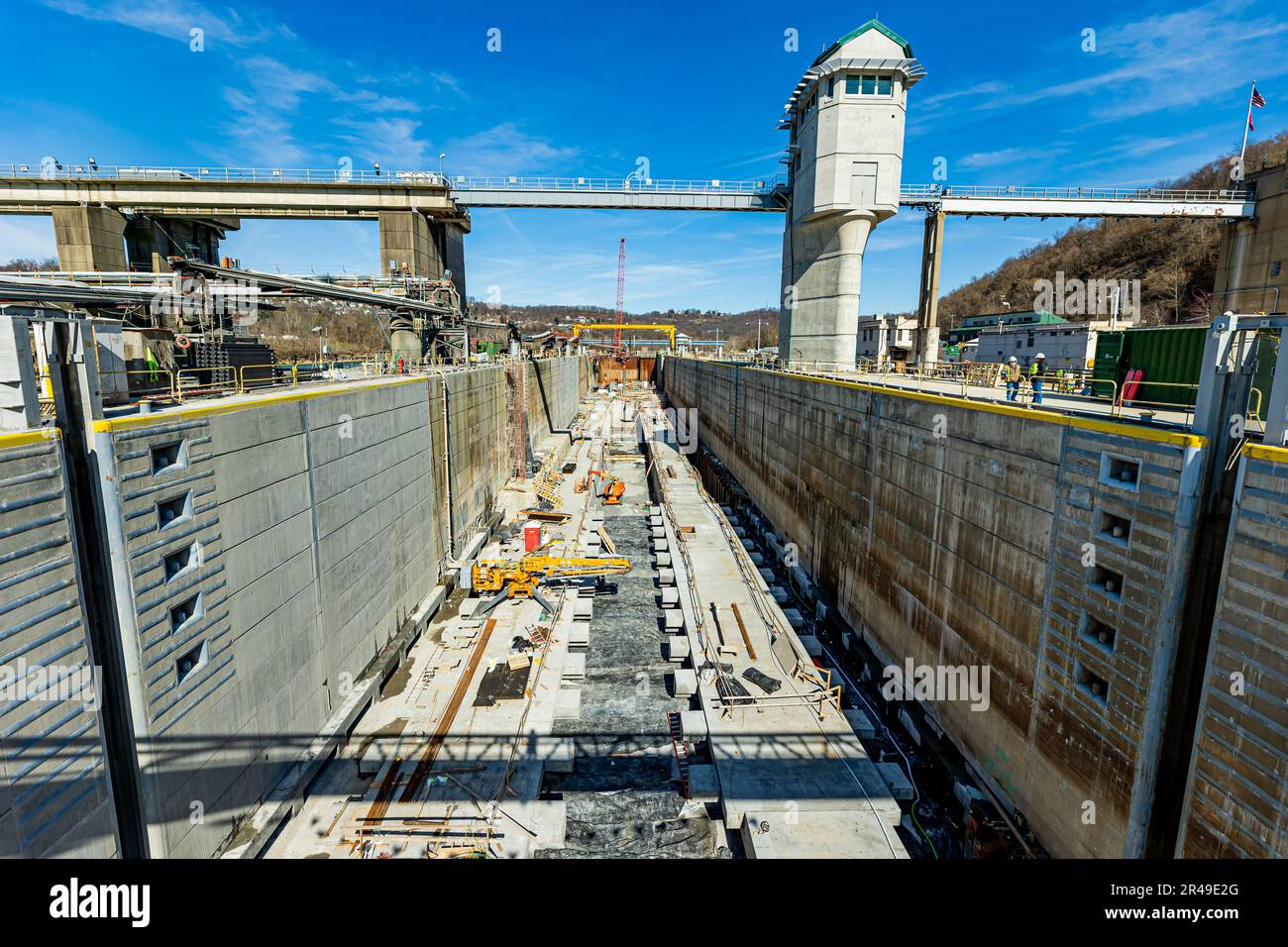 Construction laborers perform work on the chamber floor concrete infill ...