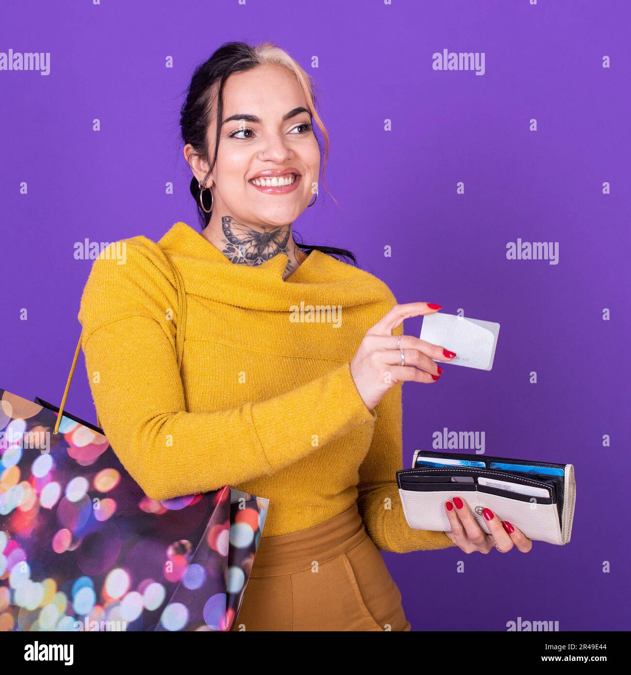 A women holding her wallet and shopping bag while showing a credit card ...