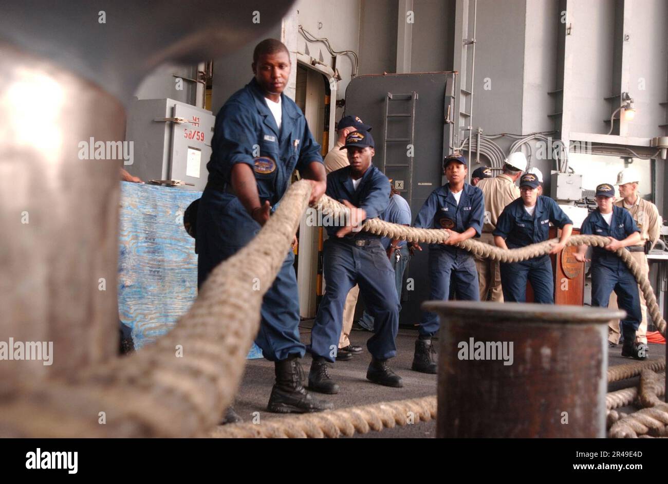 US Navy Deck Seamen handle mooring line twelve on the fantail of the ...
