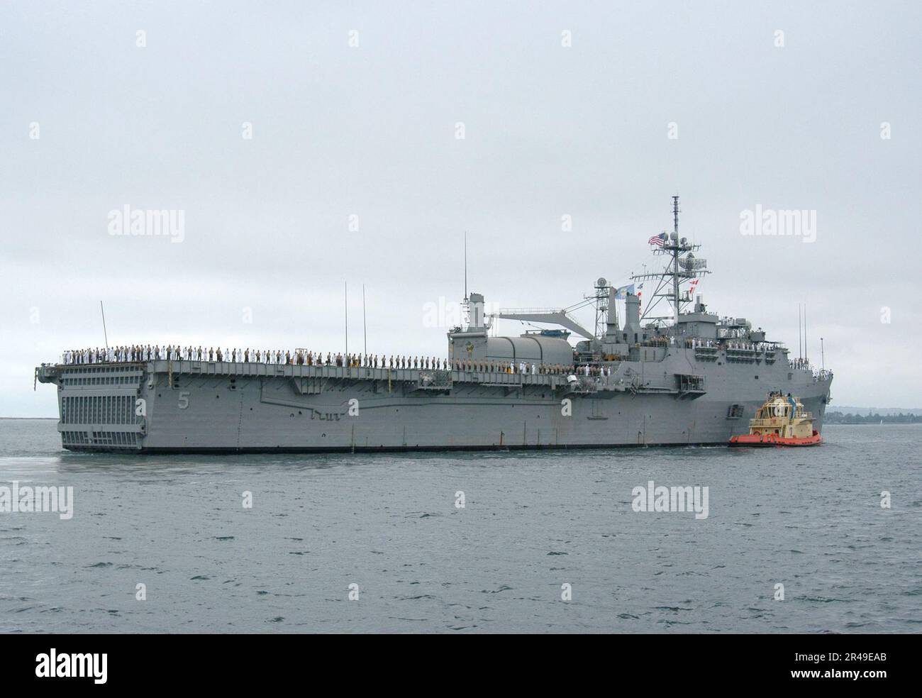 US Navy Sailors man the rails aboard USS Ogden (LPD 5) as she pulls out ...