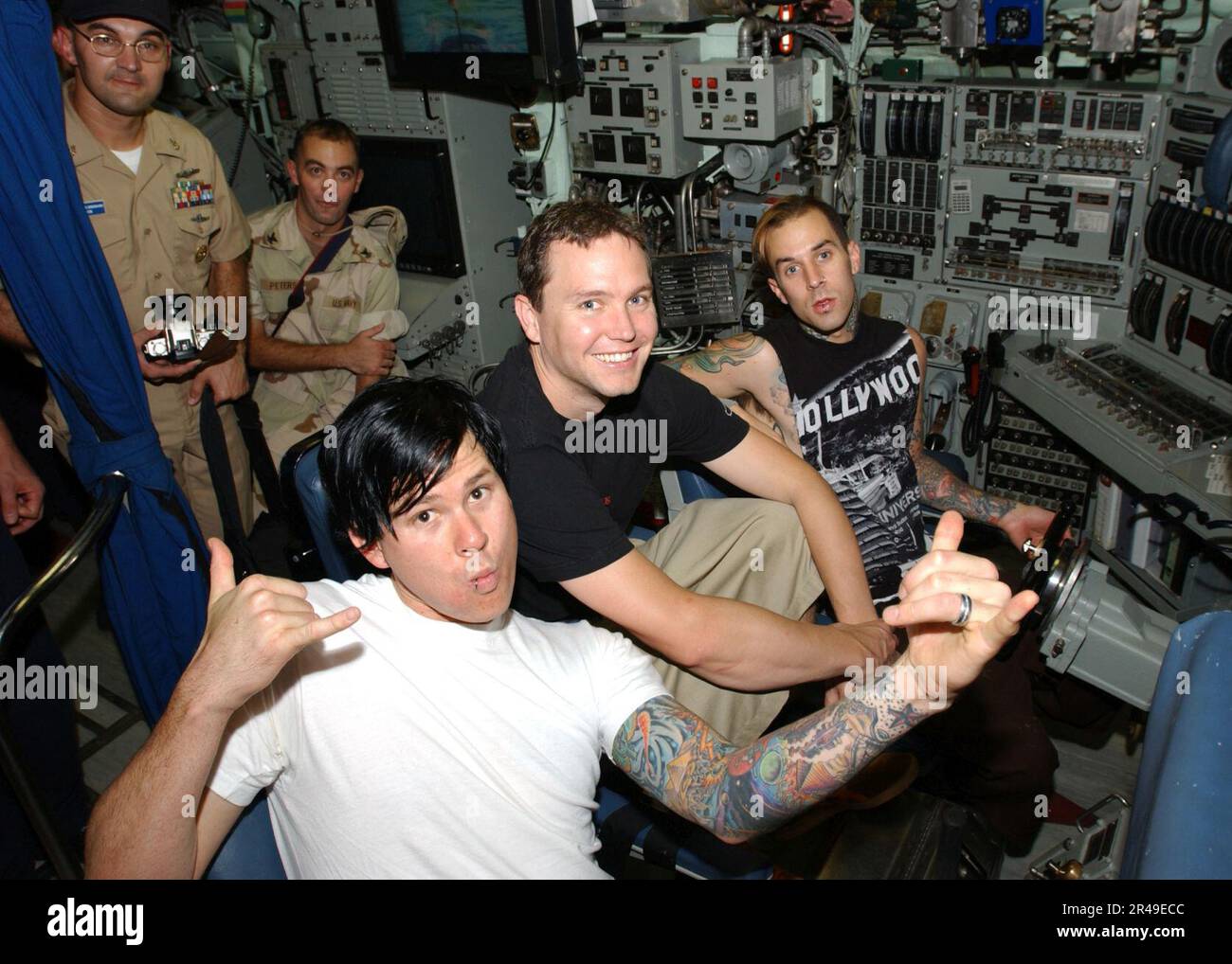 US Navy Members of the rock band Blink-182 sit at the ship's controls ...