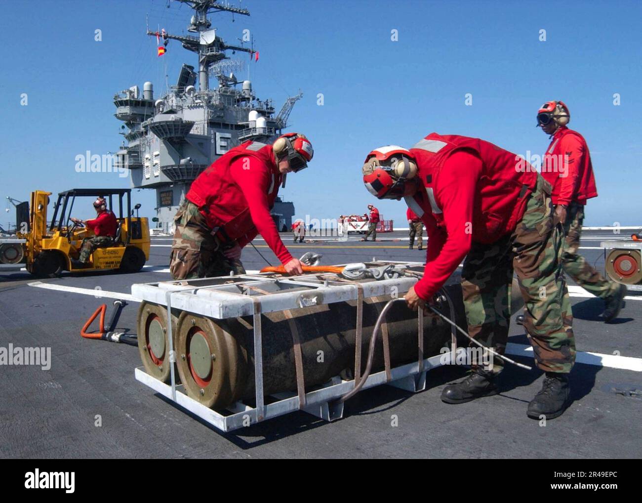 US Navy Sailors remove a hoisting sling from an ammo crate carrying ...