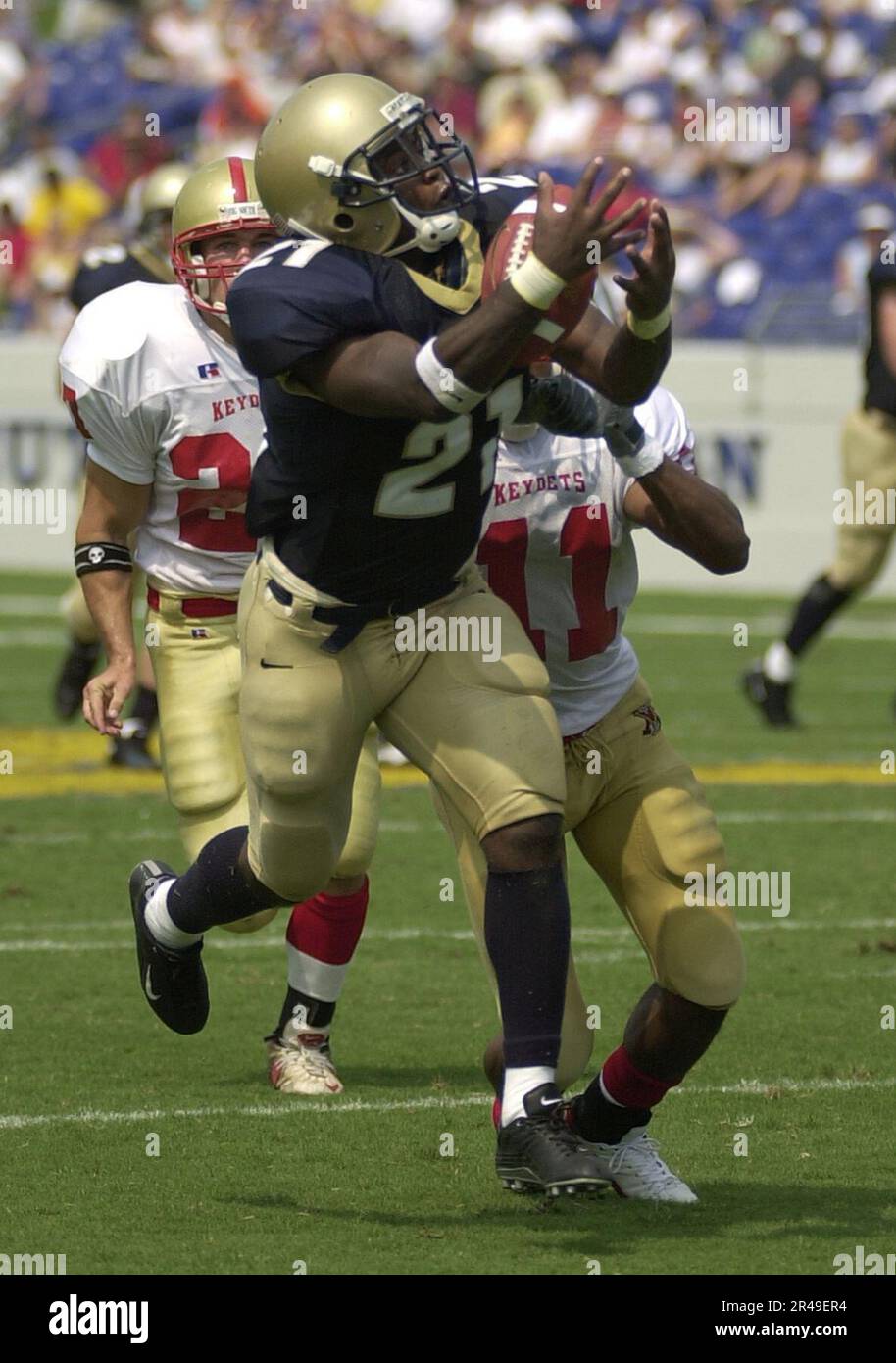 US Navy Navy slotback stretches for a reception with a line of Virginia ...