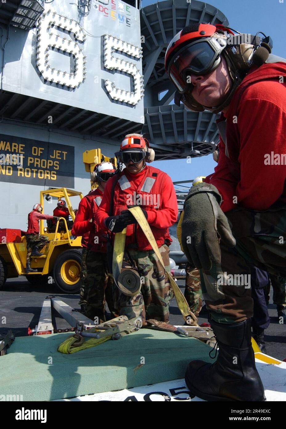 US Navy Airman surveys the scene while Aviation Boatswain's Mate 1st ...