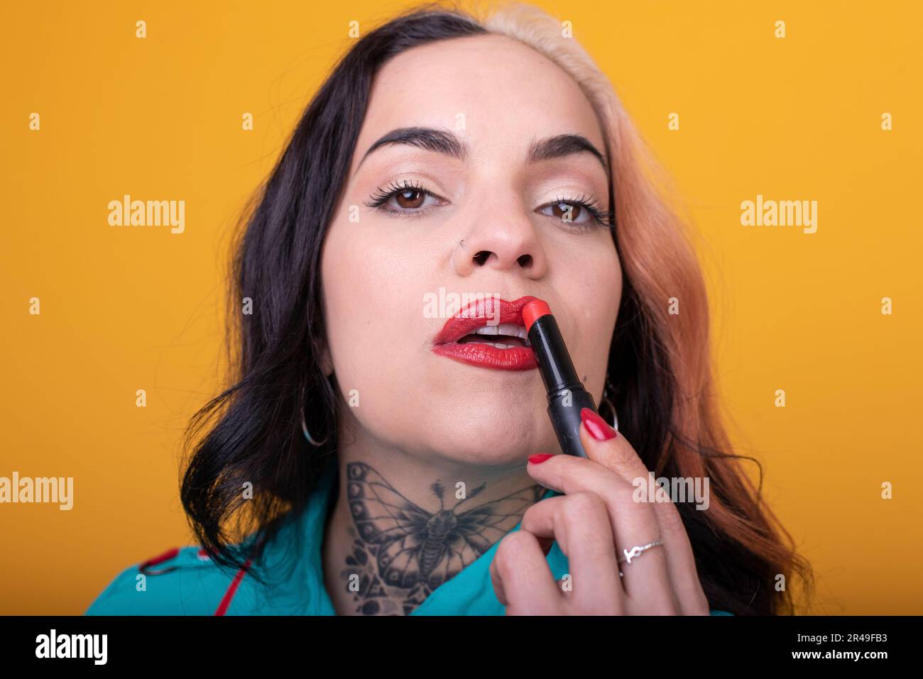 Beautiful Caucasian Woman Applying A Bright Red Color Lipstick On Her