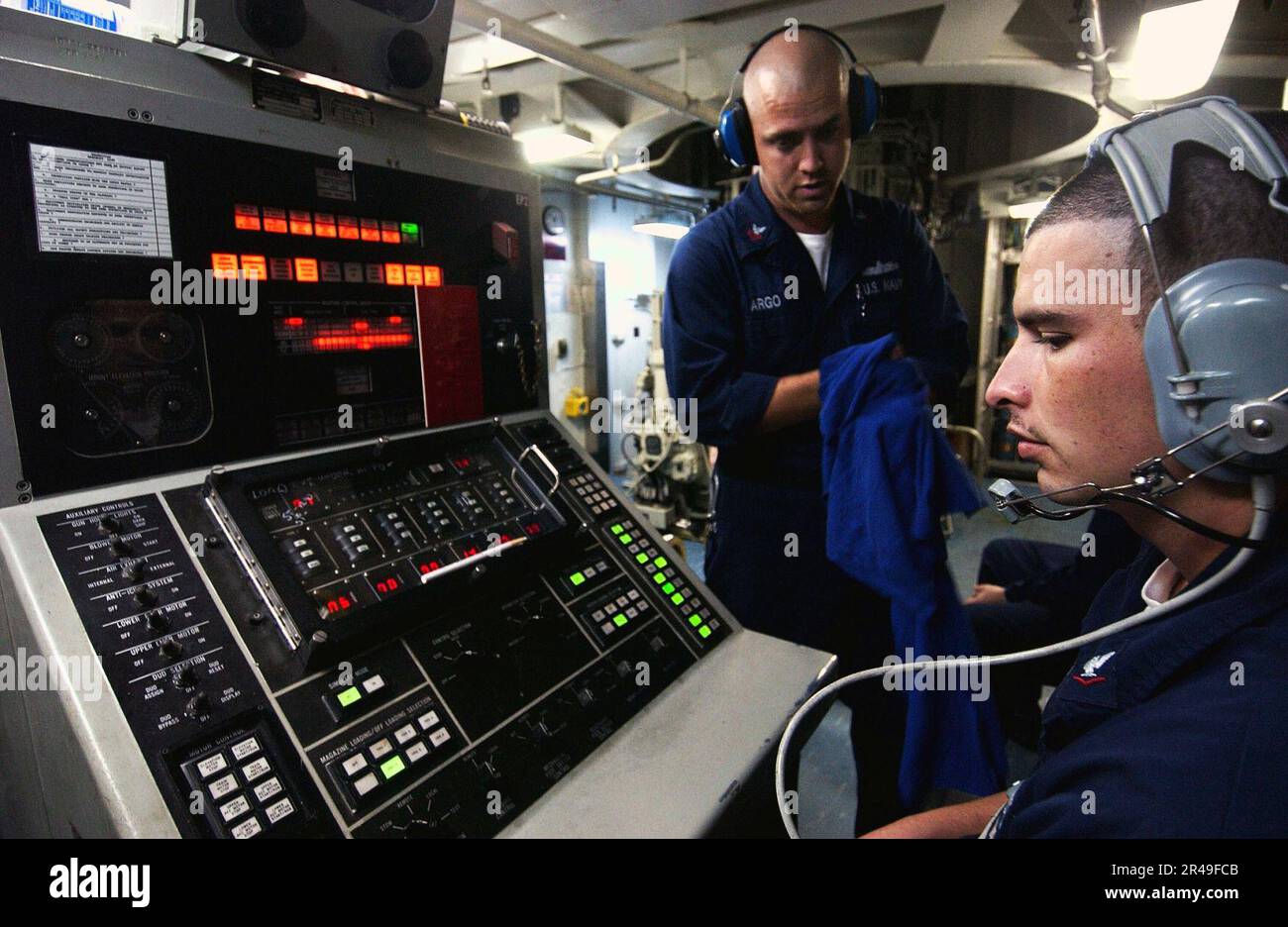 US Navy monitor the launching of 5-inch projectiles from the USS ...