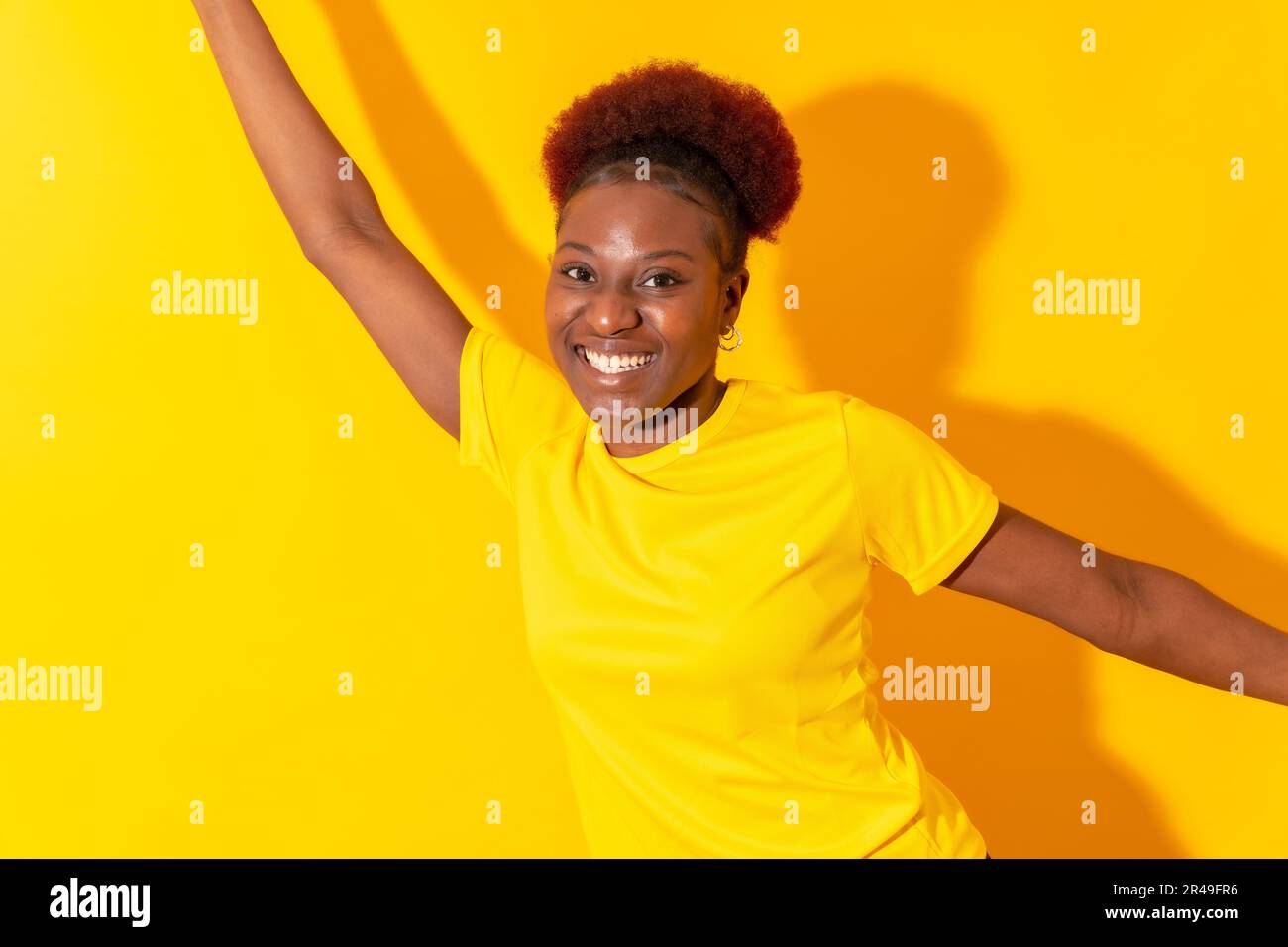 A portrait of a young cheerful black woman happily dancing Stock Photo ...