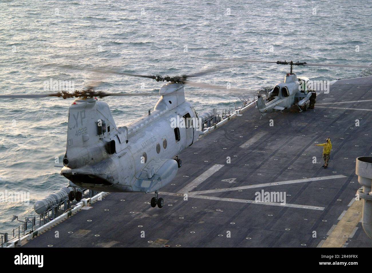 US Navy CH-46 Sea Knight and an AH-1W Cobra lift off from the flight ...