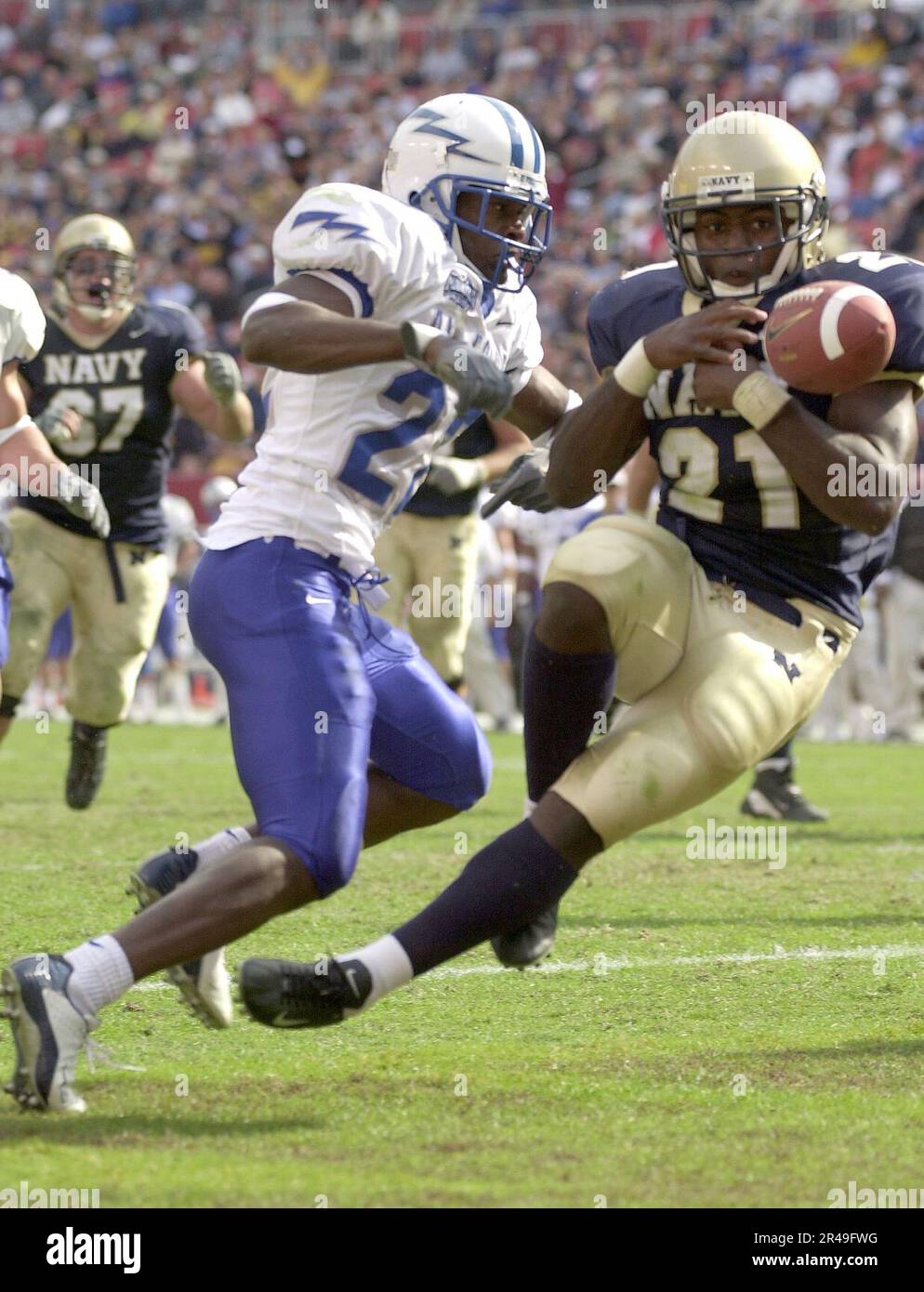 US Navy Navy slotback Tony Lane bobbles the ball and is hit by Air ...