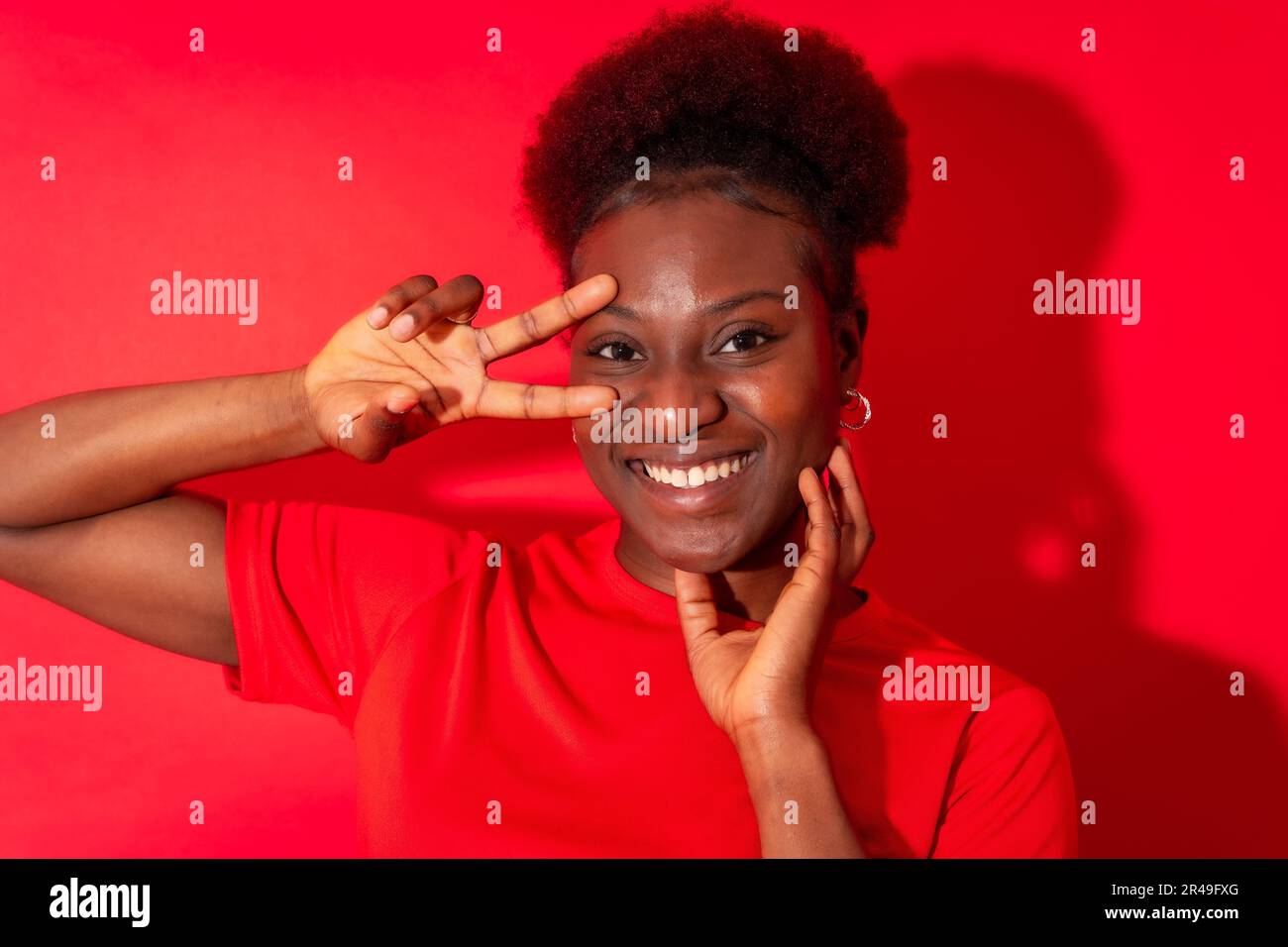 A portrait of a young cheerful black woman showing the peace sign Stock ...