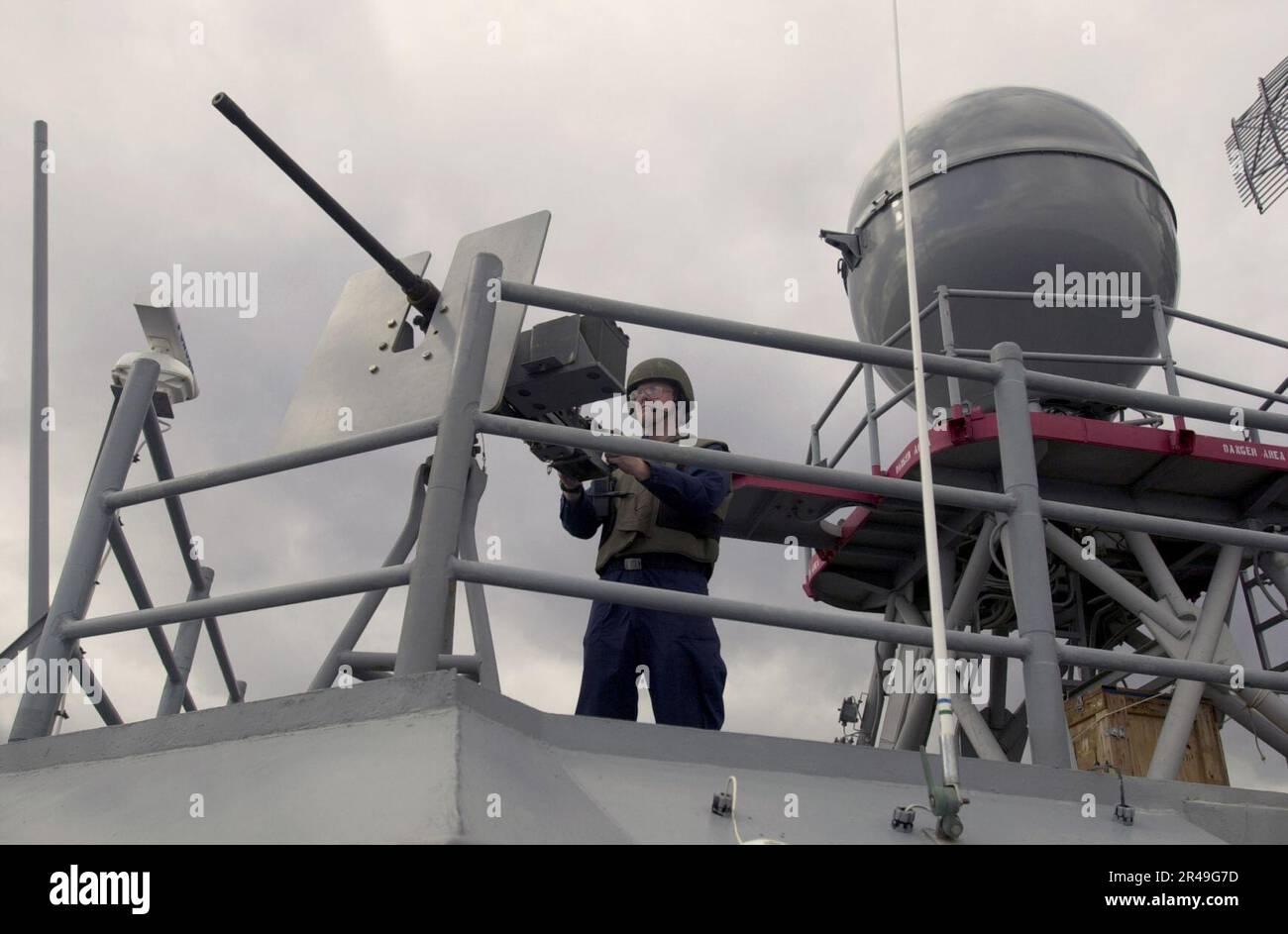 US Navy A Sailor stands guard on a forward .50 caliber machine gun ...