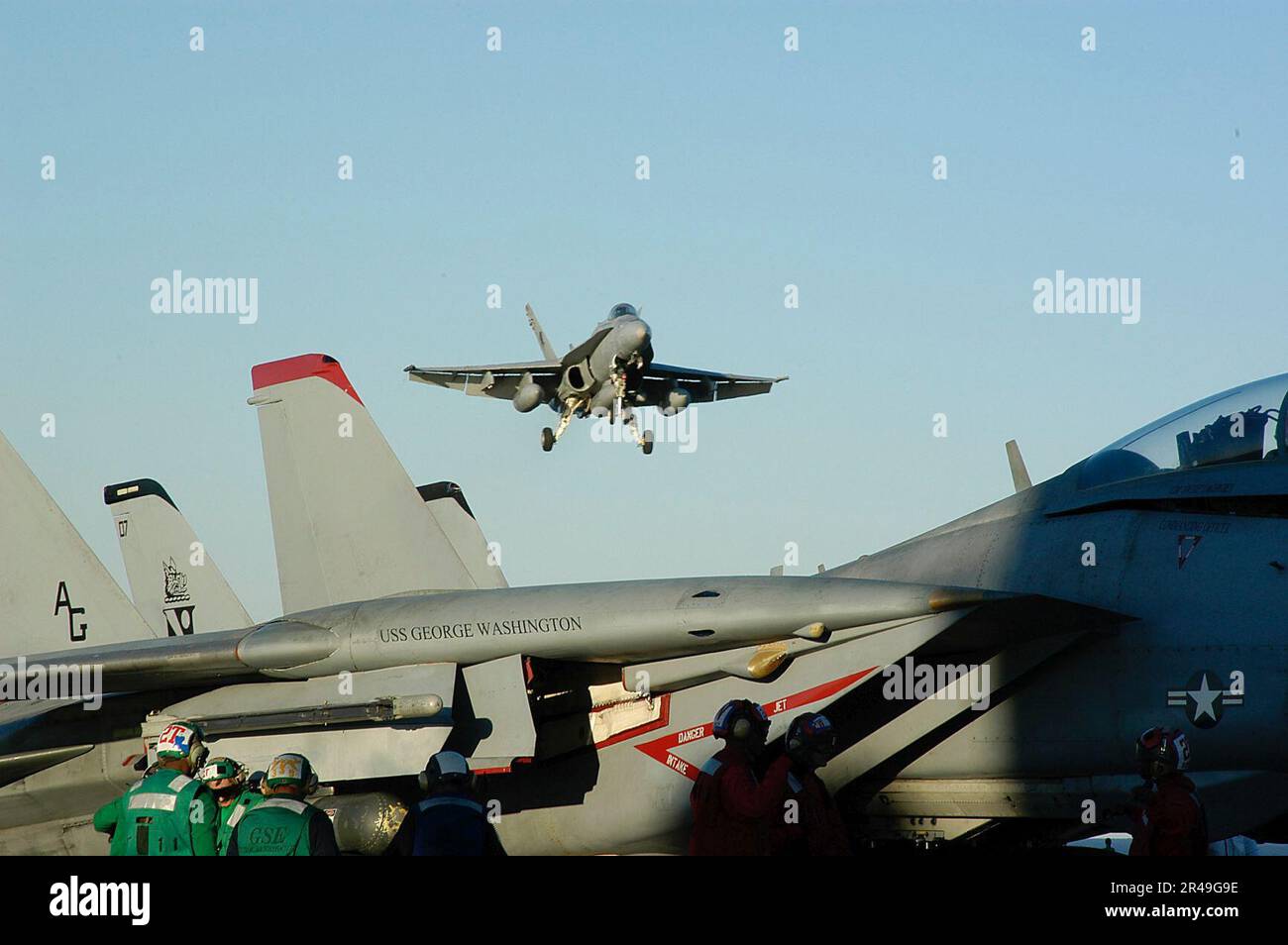 US Navy An F-A-18C Hornet flies over the flight deck of USS George ...