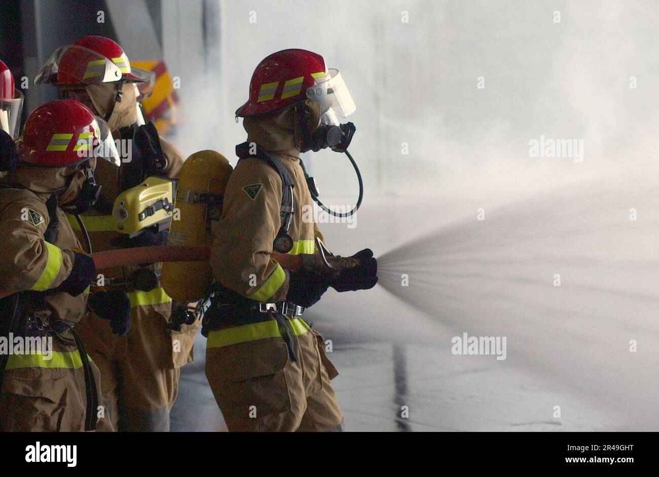 US Navy Damage Controlmen spray fire hose's off the hanger deck during ...