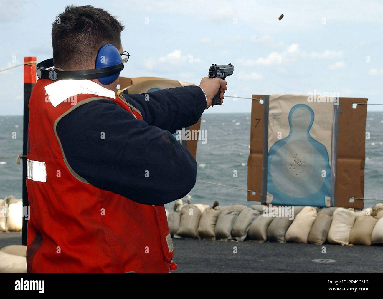 US Navy A sailor shoots a 9mm pistol for small arms qualification on ...