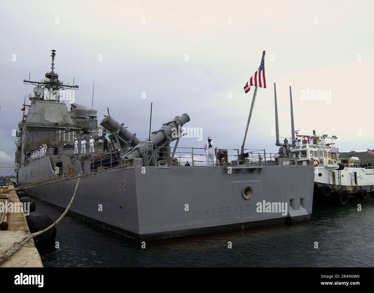 US Navy A lone Sailor stands watch on the fantail of the USS ...