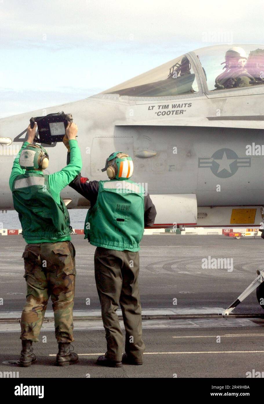 US Navy Flight deck personnel display an aircraft weight board to the ...