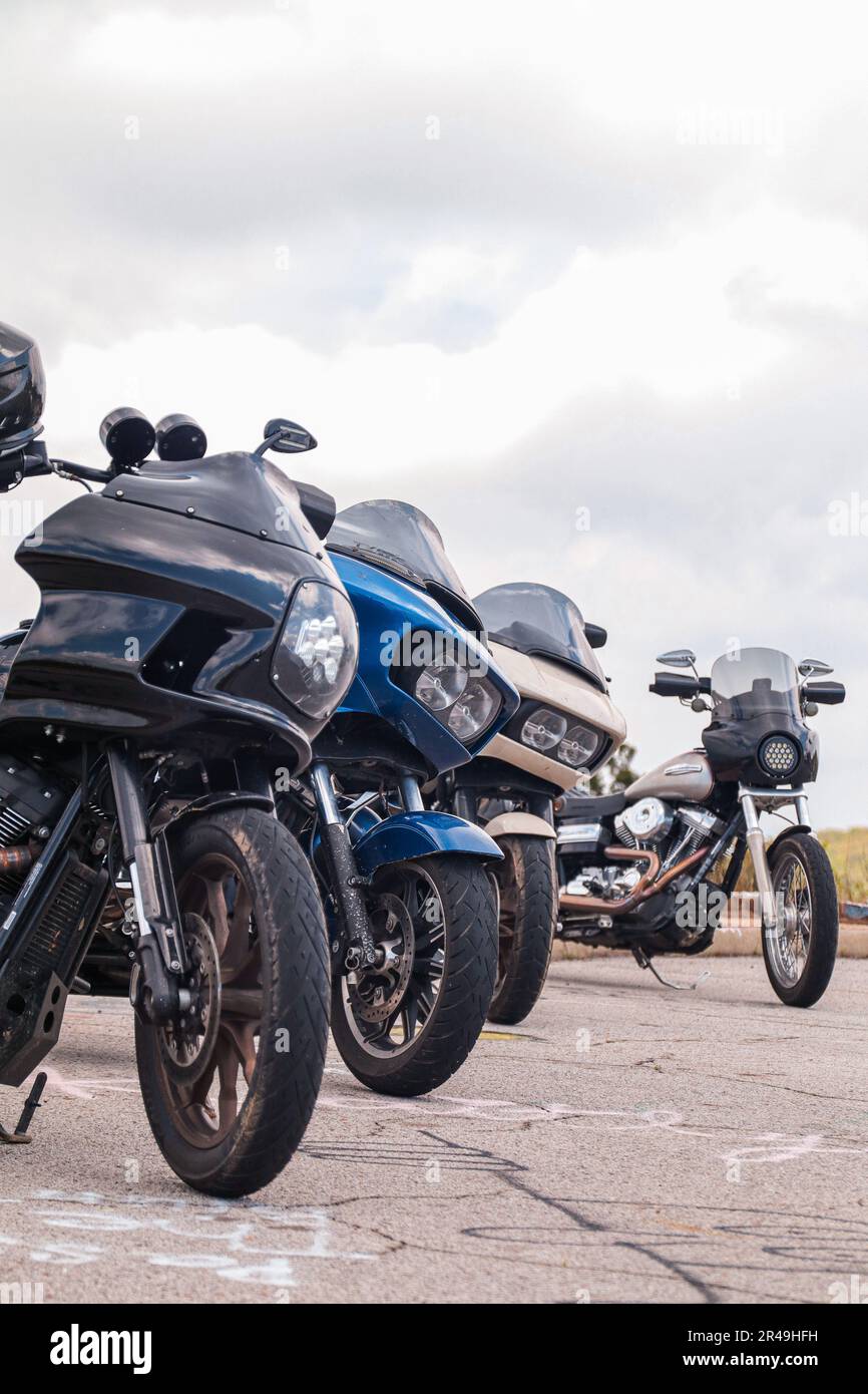 A vertical shot of two motorcycles parked on the side of a rural road ...