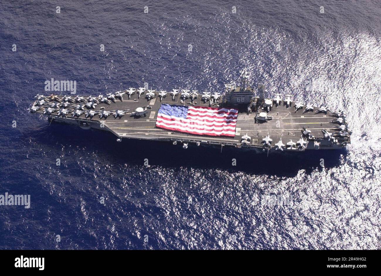 US Navy USS Nimitz (CVN 68) crewmembers participate in a flag unfurling ...