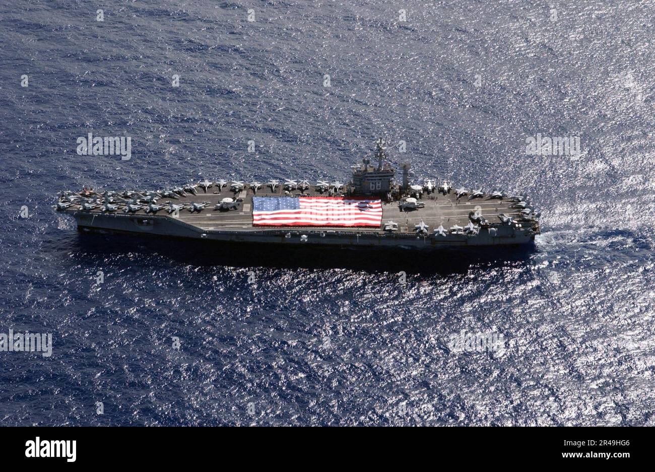 US Navy USS Nimitz (CVN 68) crewmembers participate in a flag unfurling ...