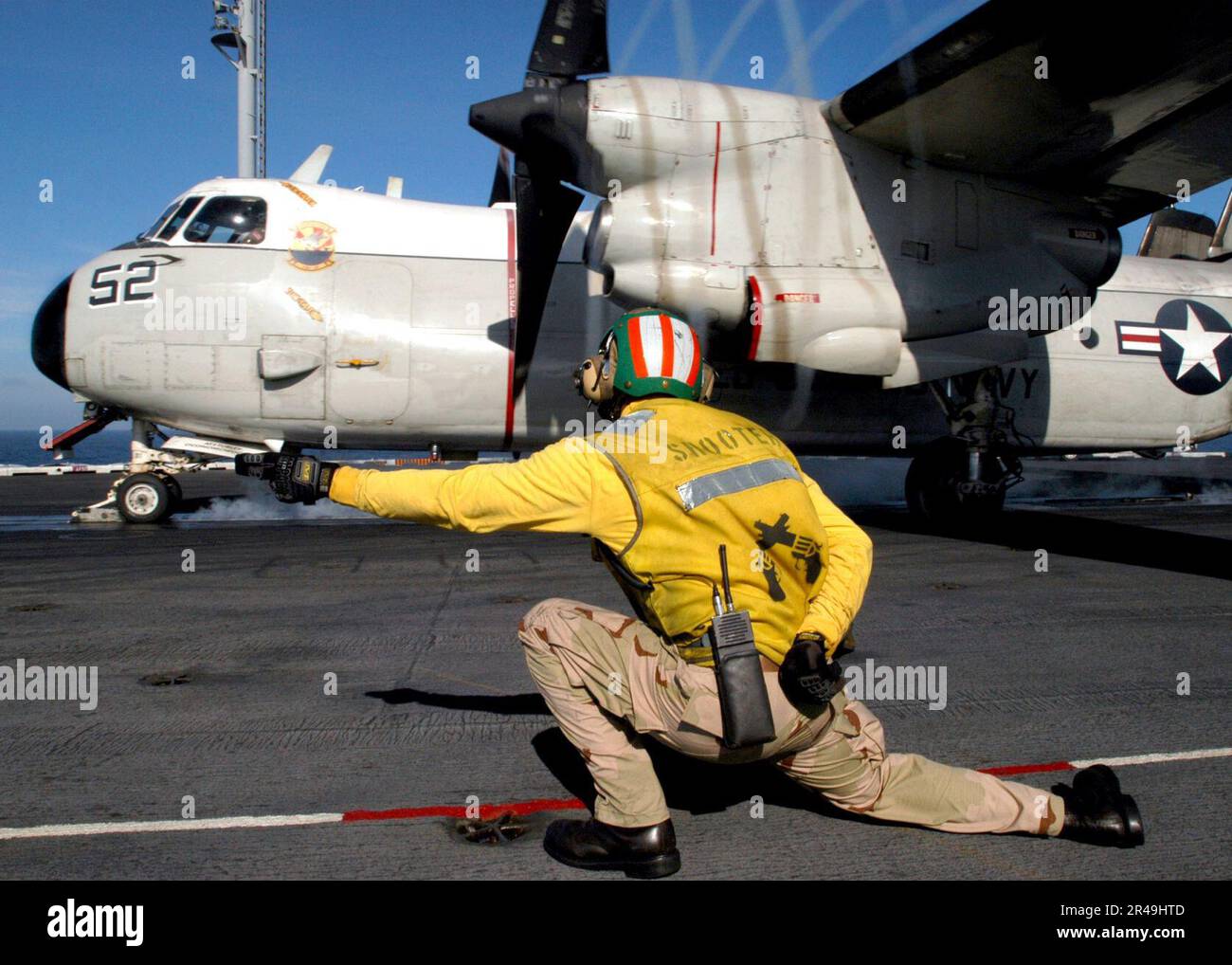US Navy A Shooter signals a C-2A Greyhound to launch from the flight ...